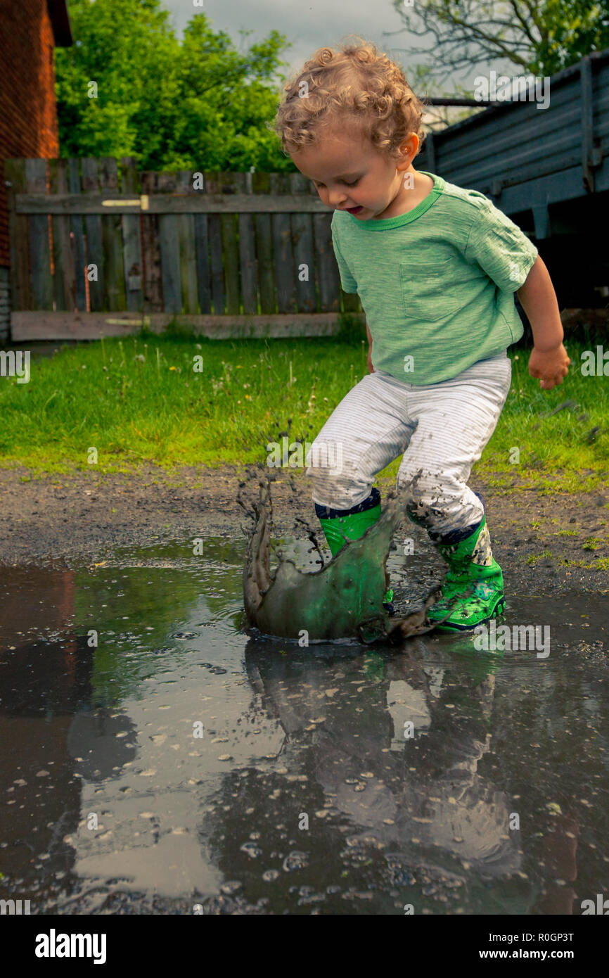 Boy playing in puddle Stock Photo - Alamy