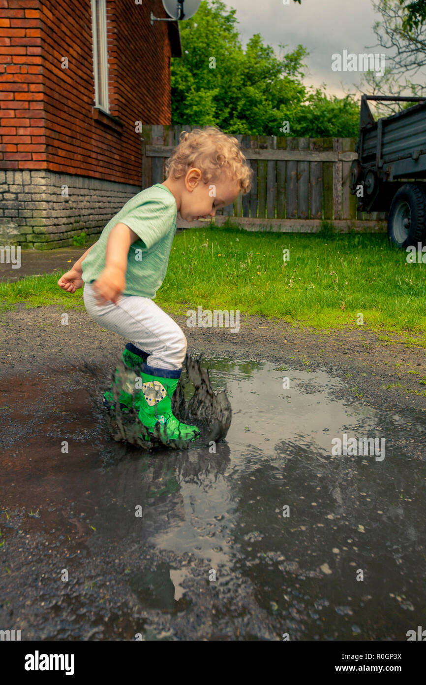 Boy playing in puddle Stock Photo - Alamy