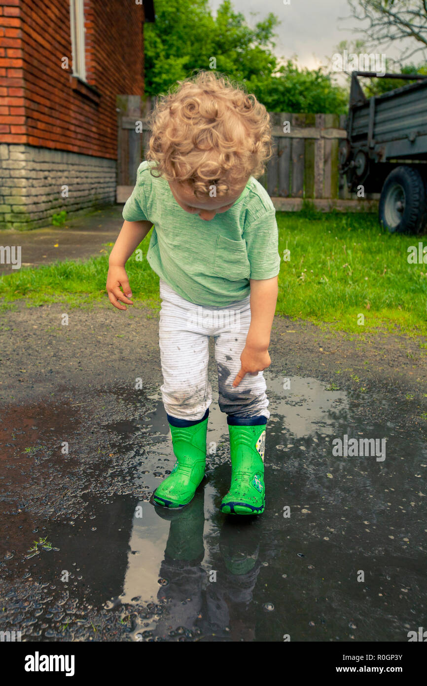 Boy playing in puddle Stock Photo - Alamy