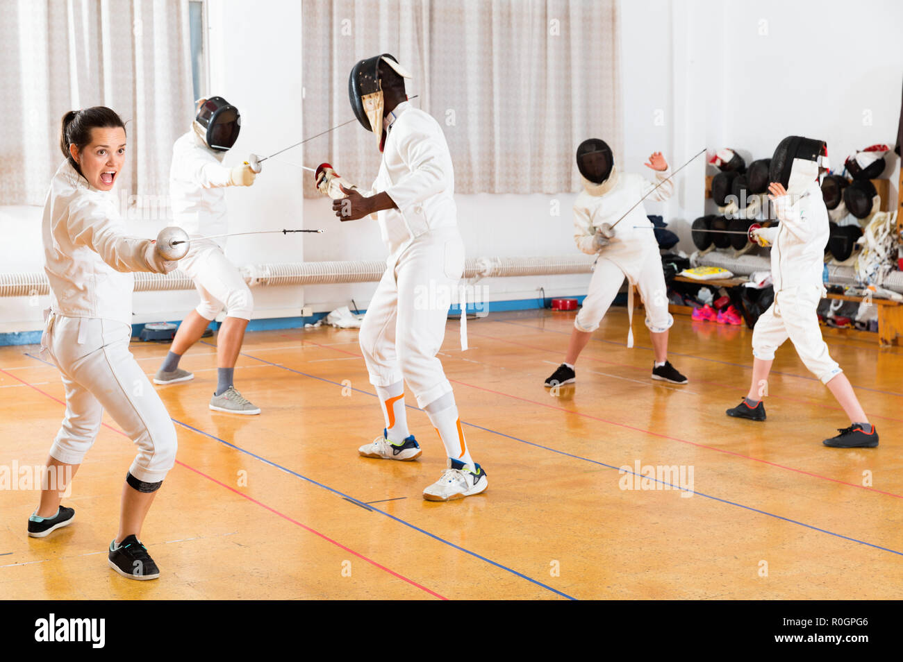 Young cheerful positive glad woman fencer practicing effective fencing ...