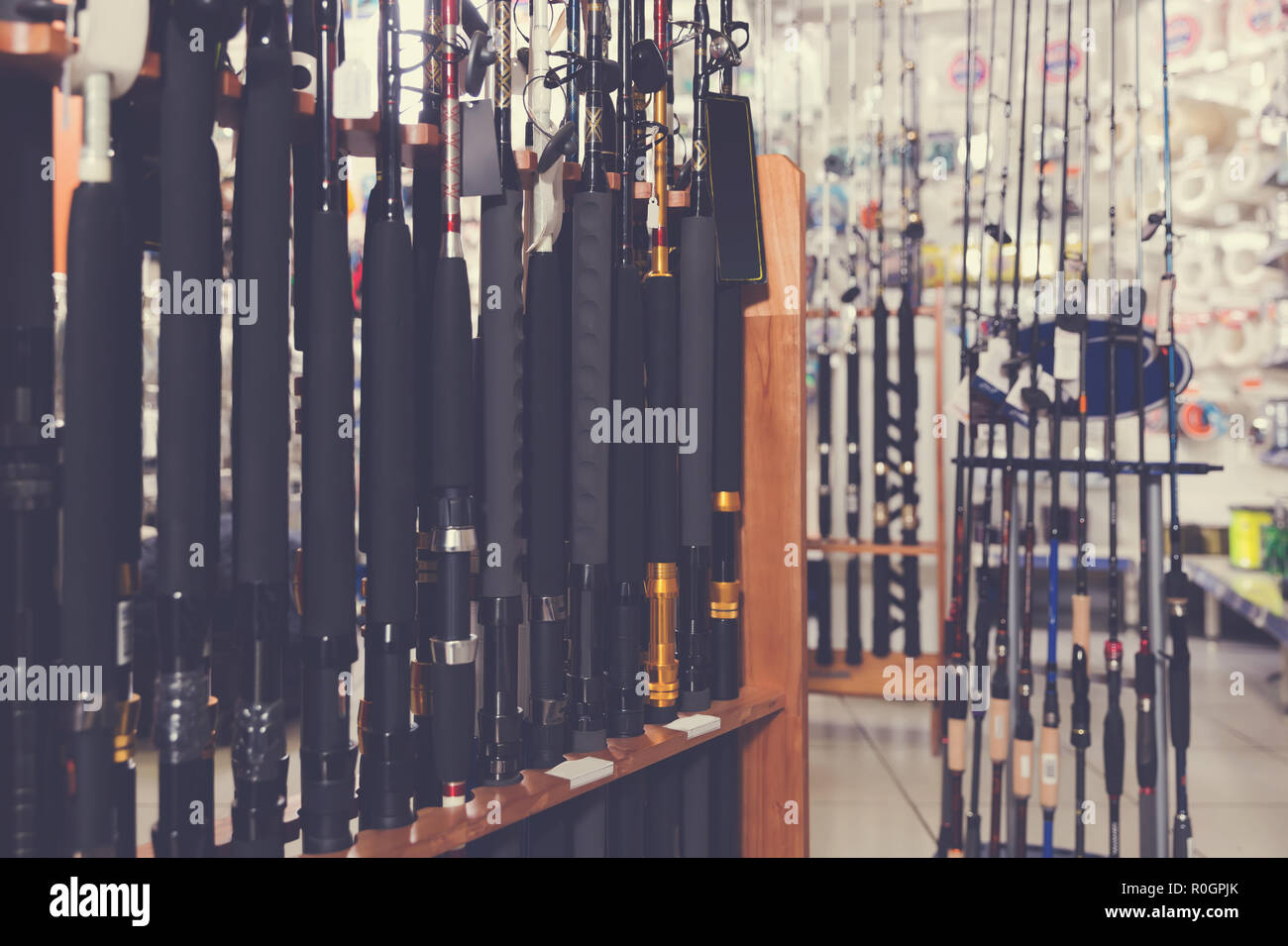 Image of stand with various fishing rods in the sports shop indoor ...