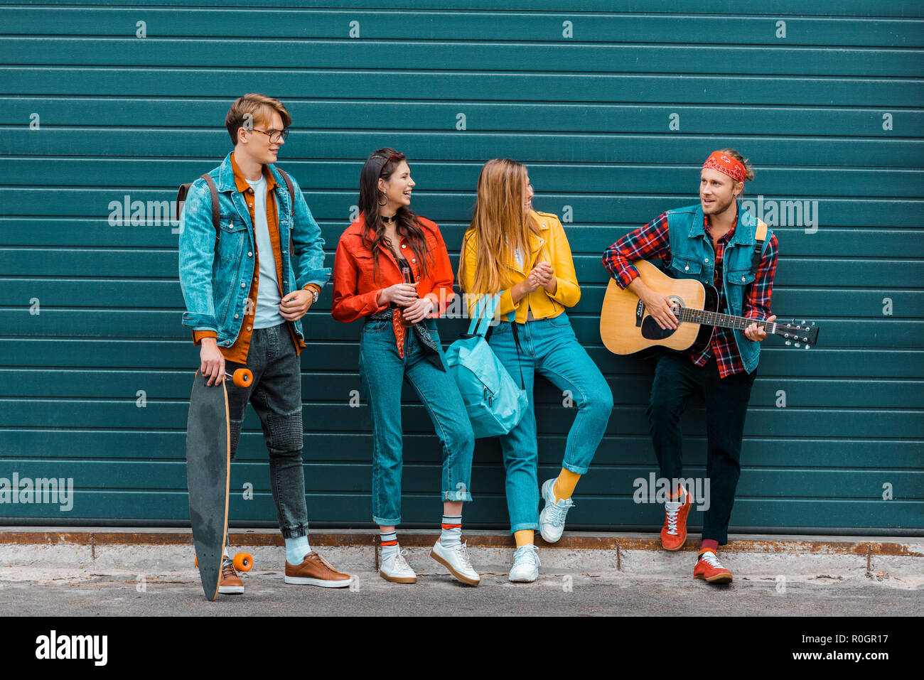 stylish hipsters spending time with acoustic guitar and skateboard ...