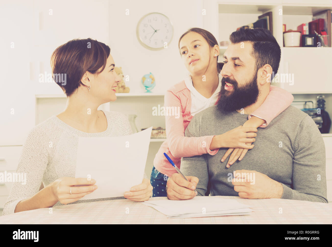 Young parents signing papers for new house with their daughter Stock ...
