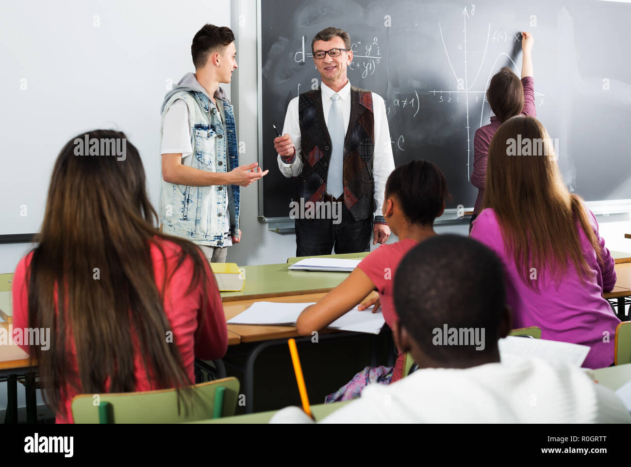 Students listening the explanation and answering to a teacher in the ...