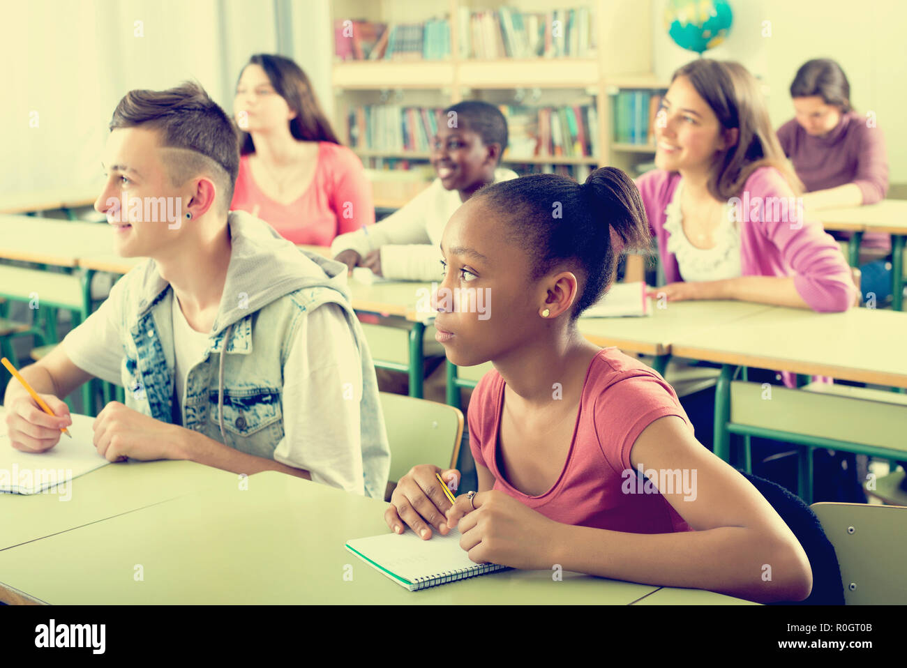 Positive multiethnic students studying together in the classroom Stock ...