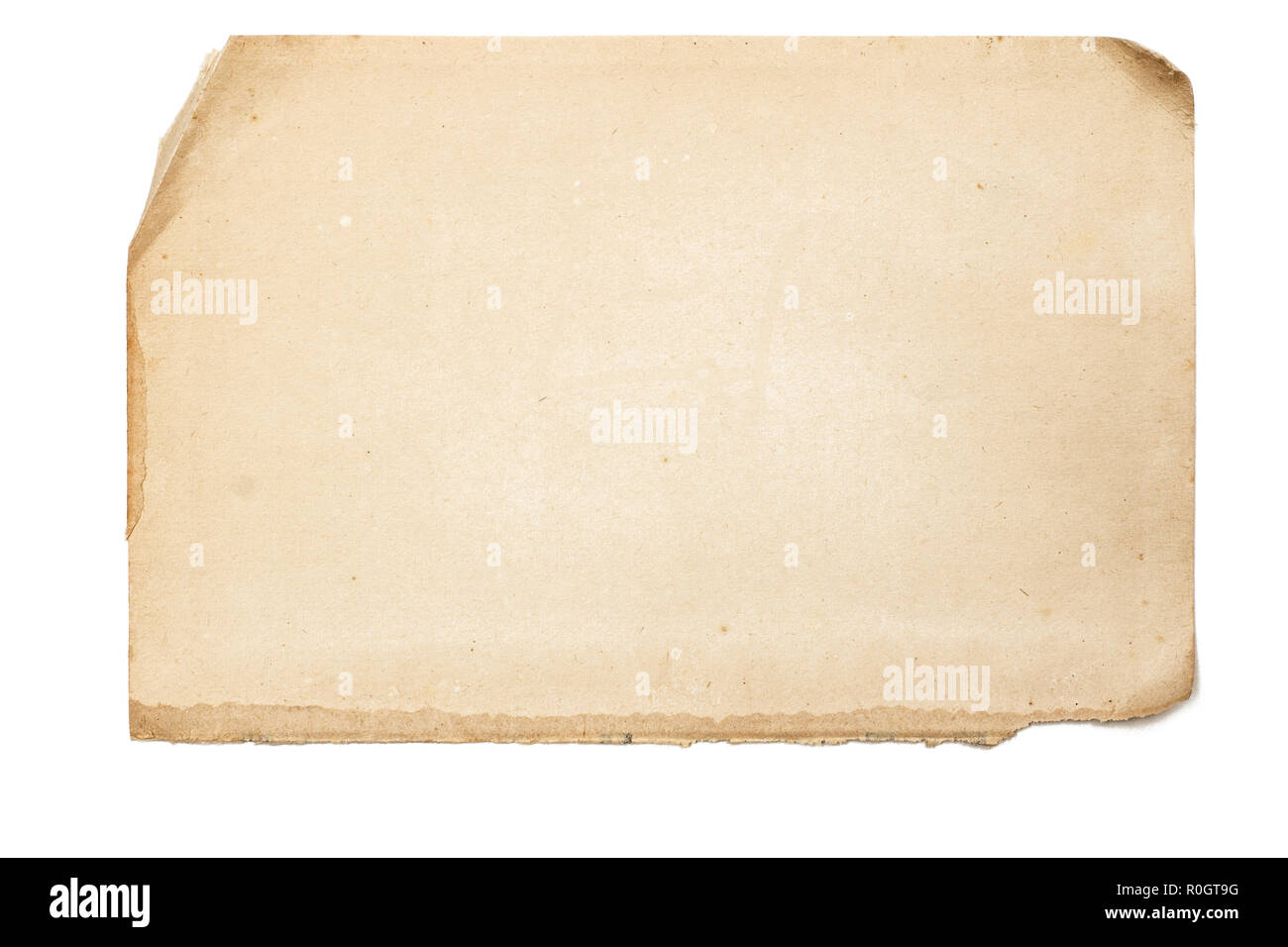 Sheet of old yellowed paper with inclusions, blemishes and uneven torn ...