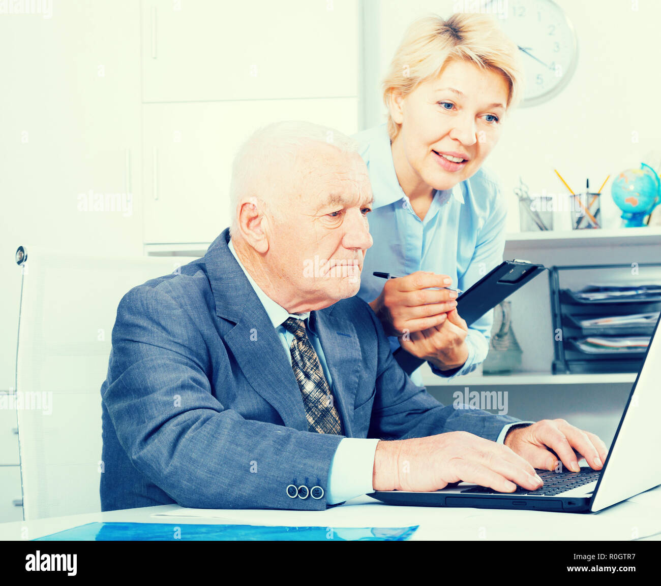 Senior manager and secretary working effectively together in office ...