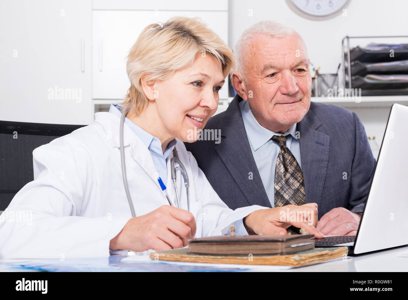 Mature male client visiting consultation with woman doctor in hospital ...