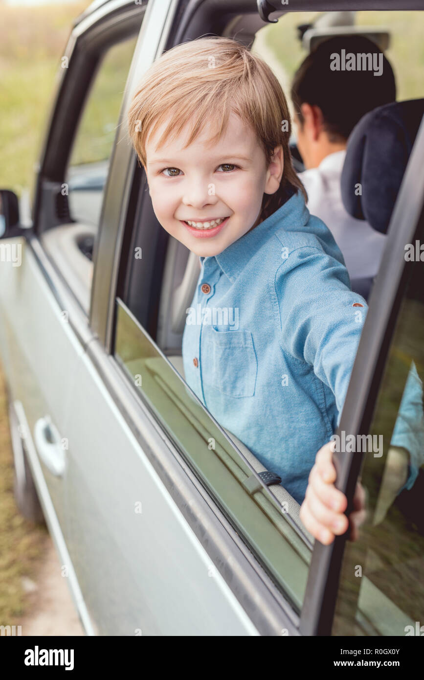happy little kid riding car with his dad on nature and looking at ...