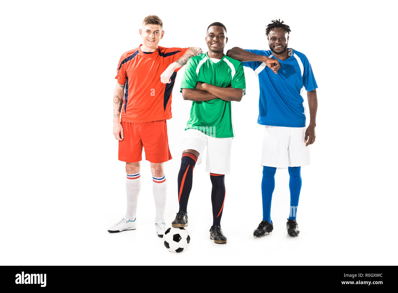 happy young multiethnic soccer players standing together and smiling at ...