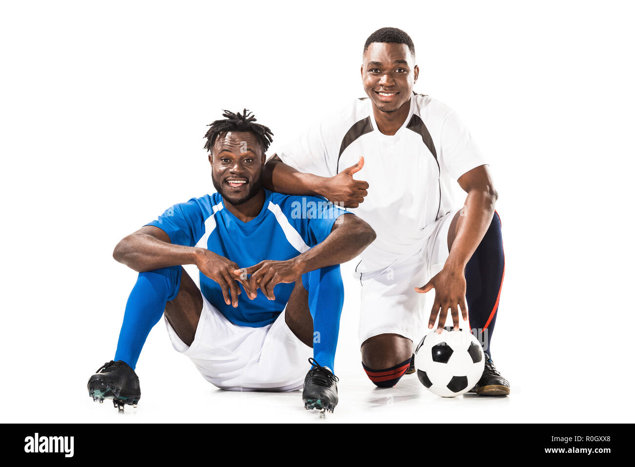 happy african american soccer players smiling at camera and showing ...