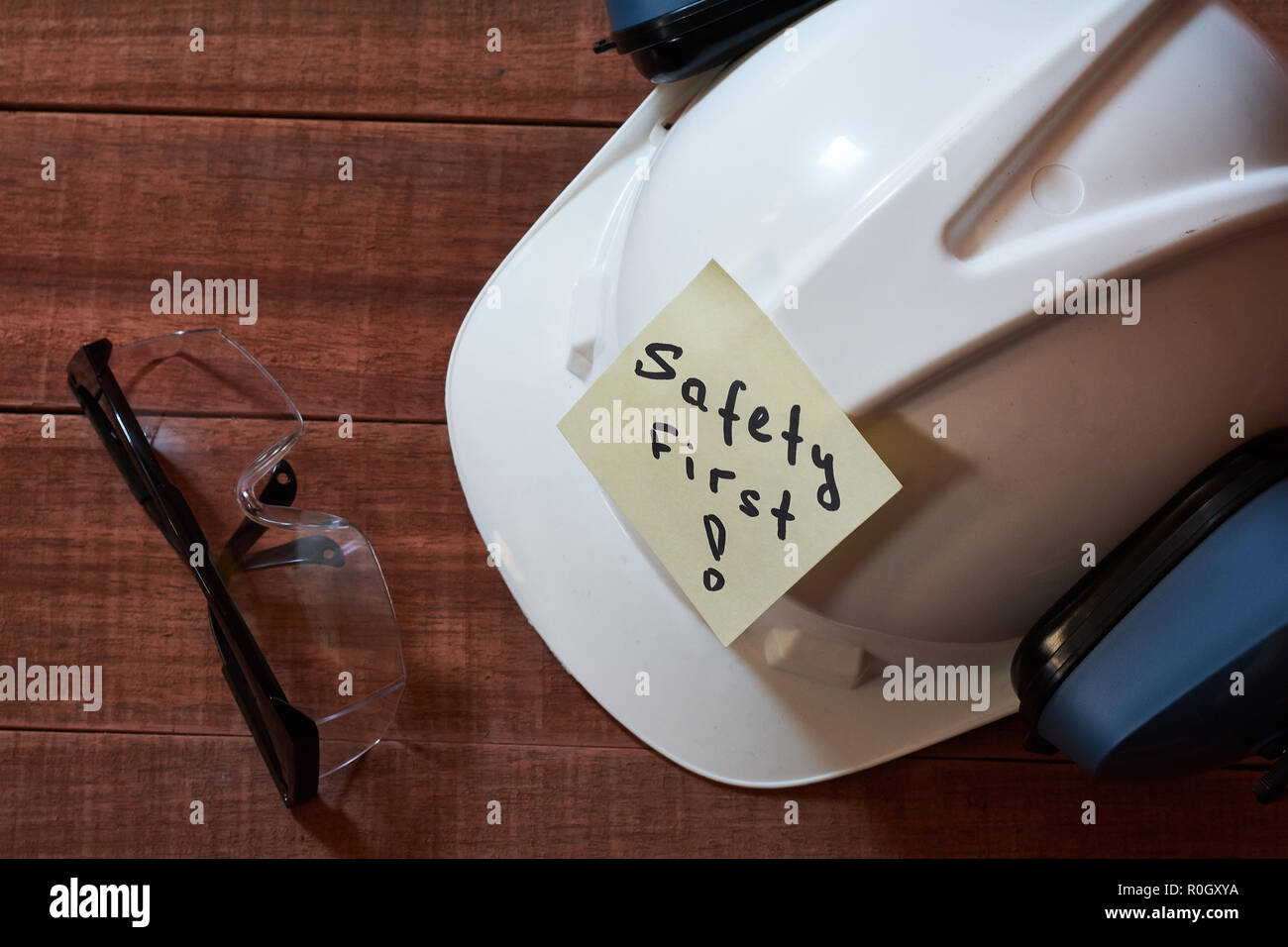 Safety first note one yellow piece of paper stuck on wooden background ...