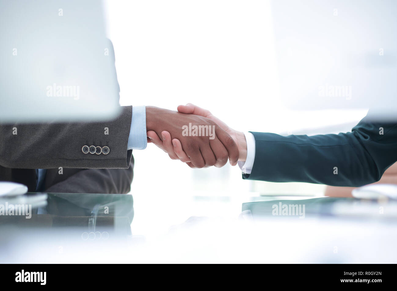 background image of handshake of business partners above the Desk Stock ...