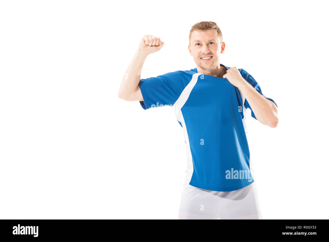 triumphing young sportsman shaking fist and smiling isolated on white ...