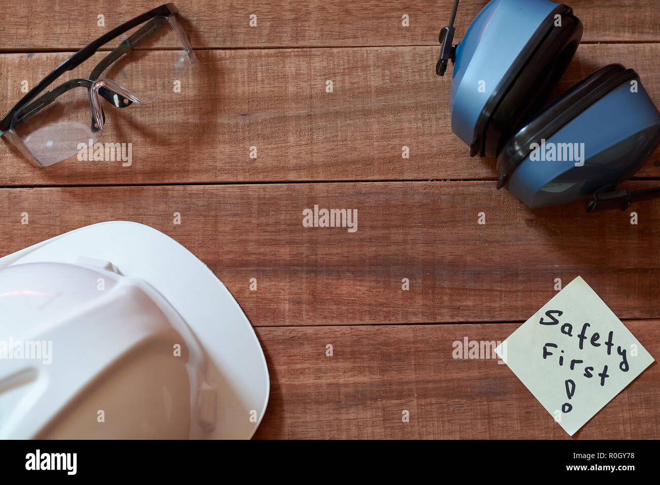 Safety first note one yellow piece of paper stuck on wooden background ...