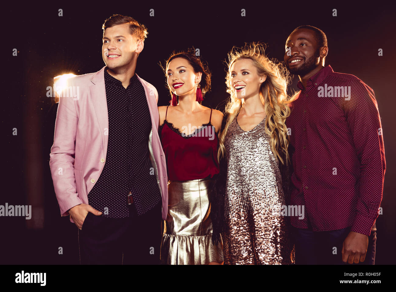 luxury multicultural friends looking away on black with backlit Stock ...