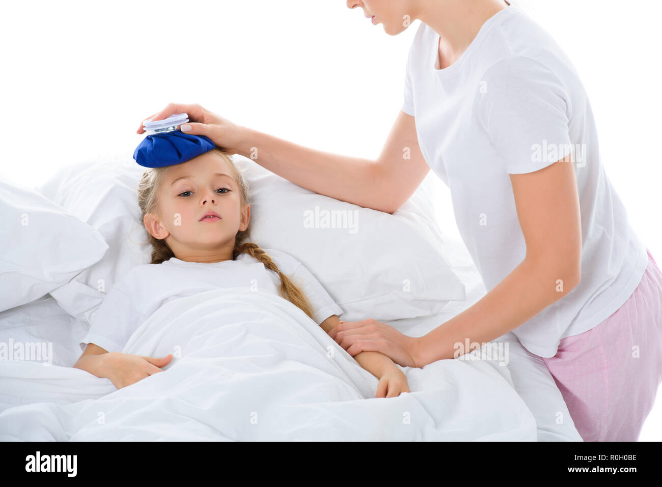 parent holding ice pack on head of sick daughter with temperature lying ...