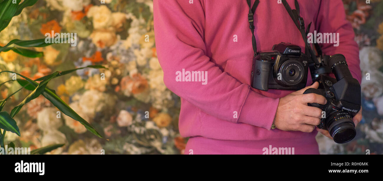 Self portrait of photographer holding analog cameras Stock Photo - Alamy