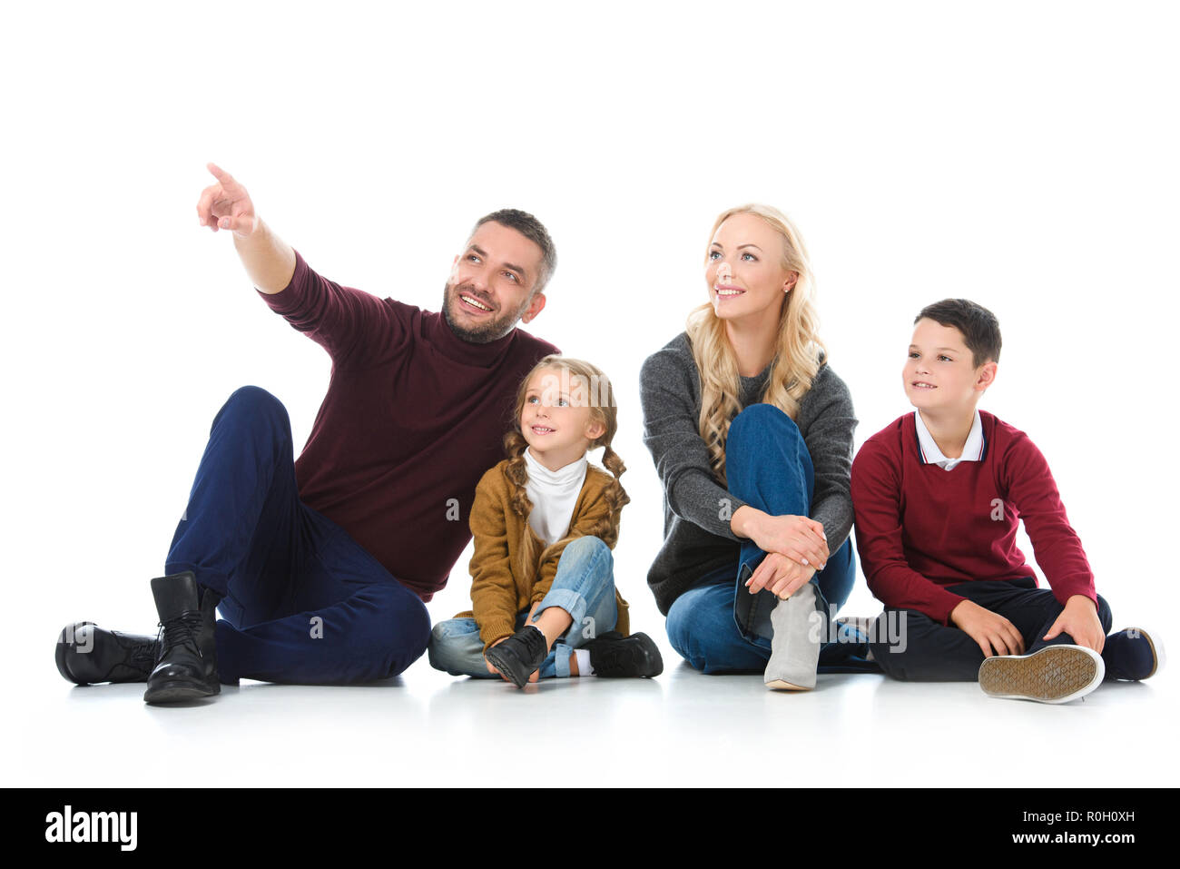 happy parents sitting together with kids, father showing something ...