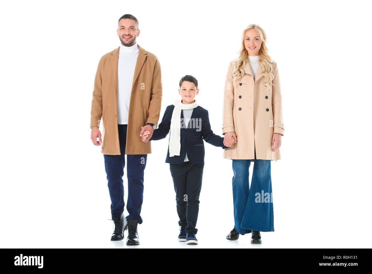 parents in beige coats and son holding hands, isolated on white Stock ...