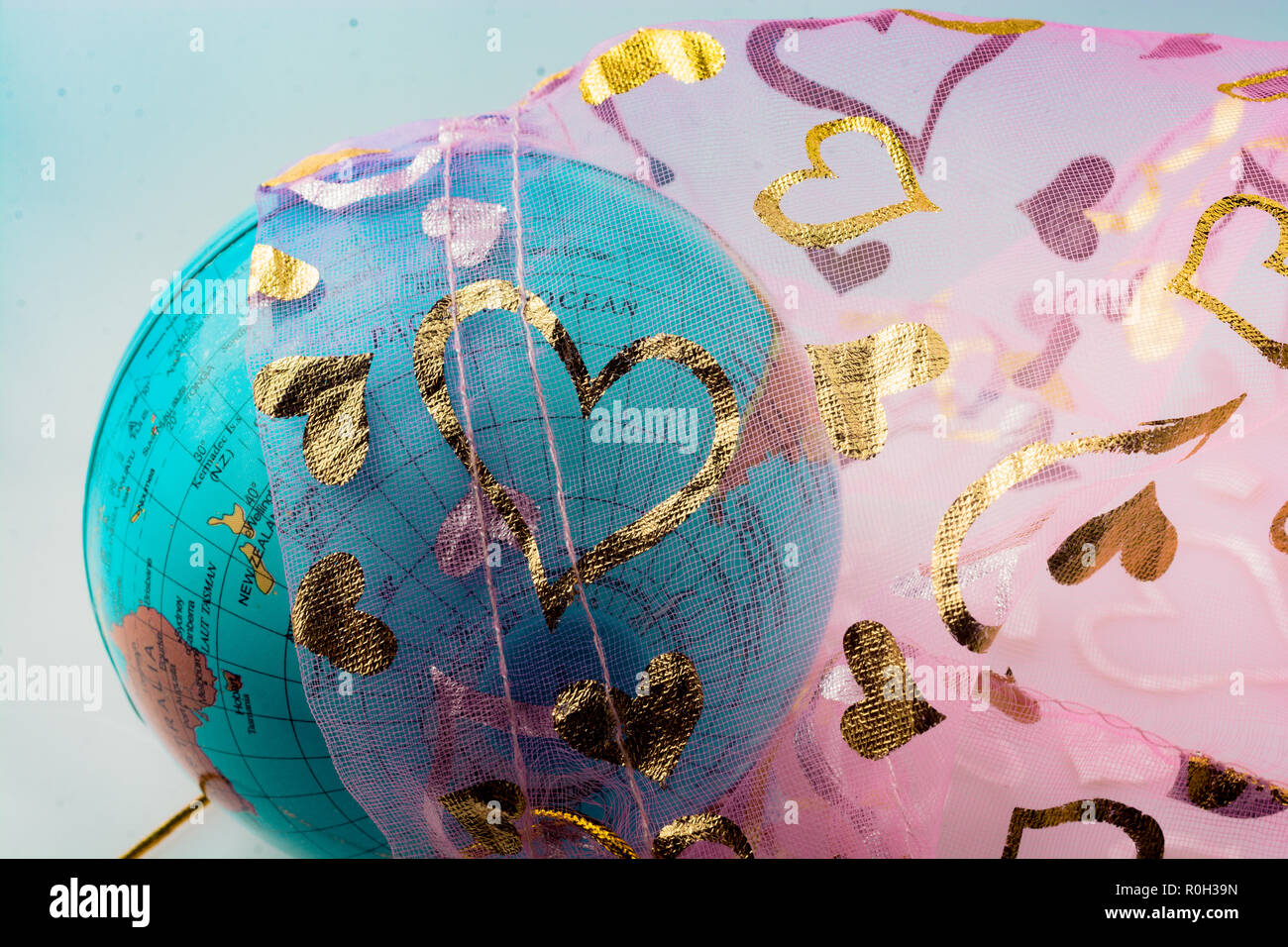 Little model globe under a fabric with heart patterns Stock Photo - Alamy