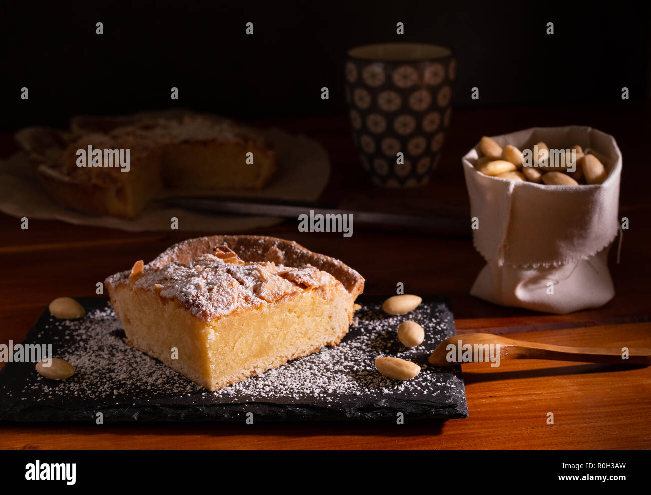 freshly homemade almond frangipane cake in selective lighting with ...