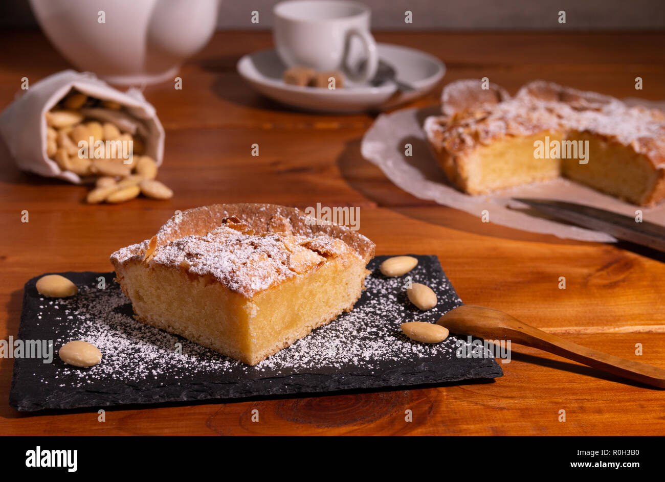 freshly homemade almond frangipane cake in selective lighting with ...