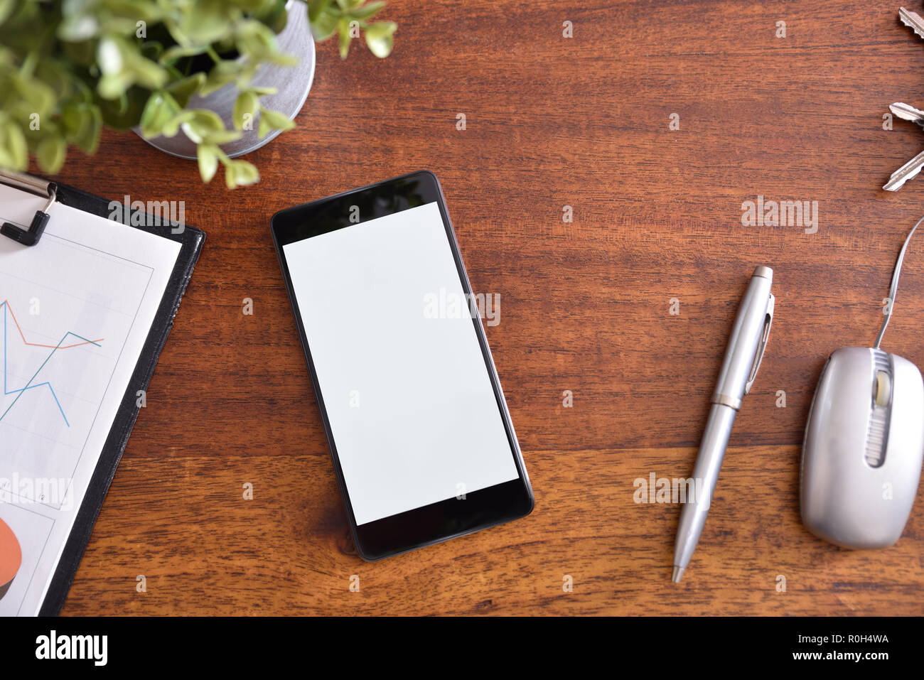 Business desk with a smartphone on wood table in the office. Horizontal ...