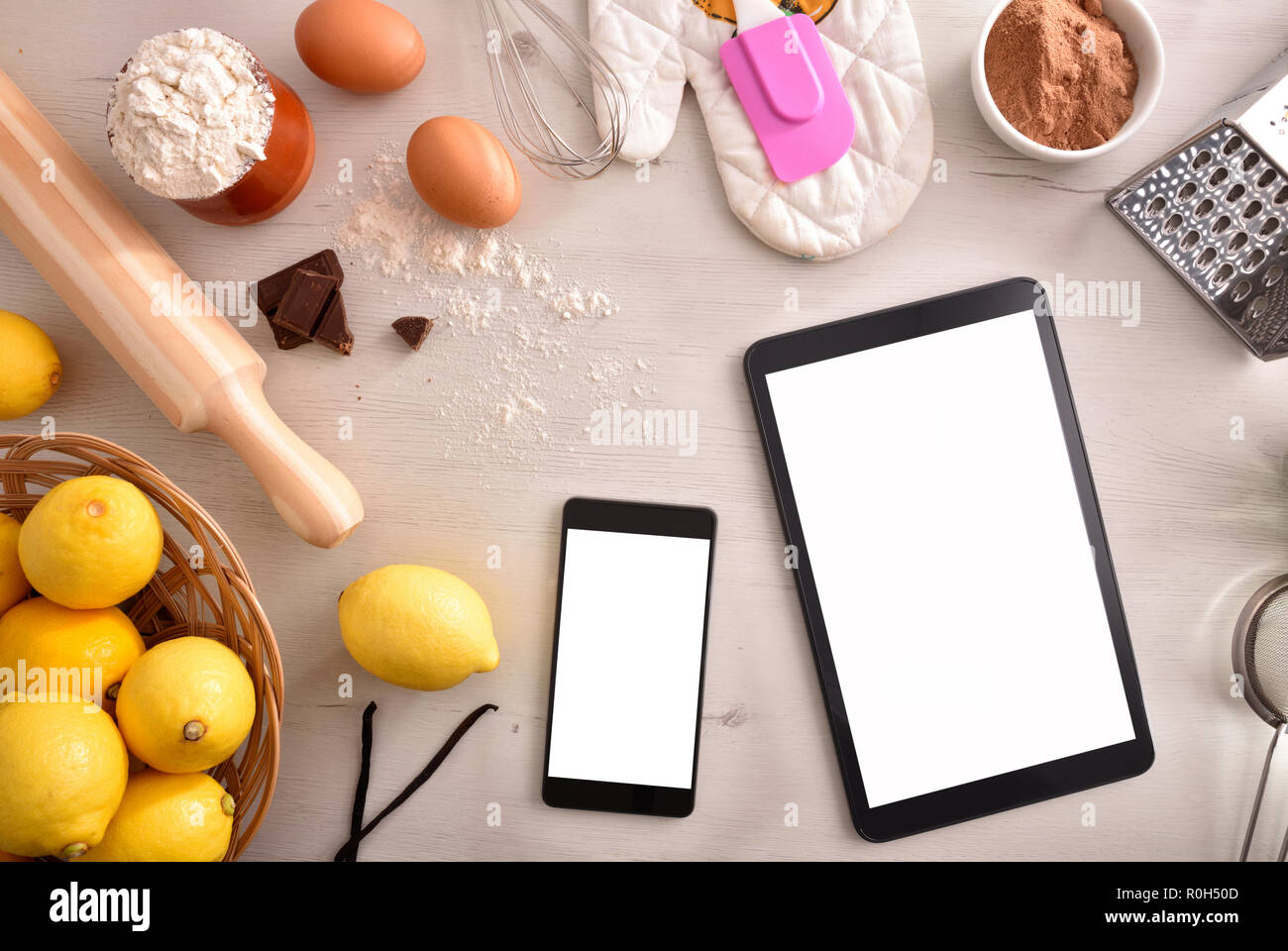 Pastry ingredients on a white wooden table and mobile devices. Concept ...