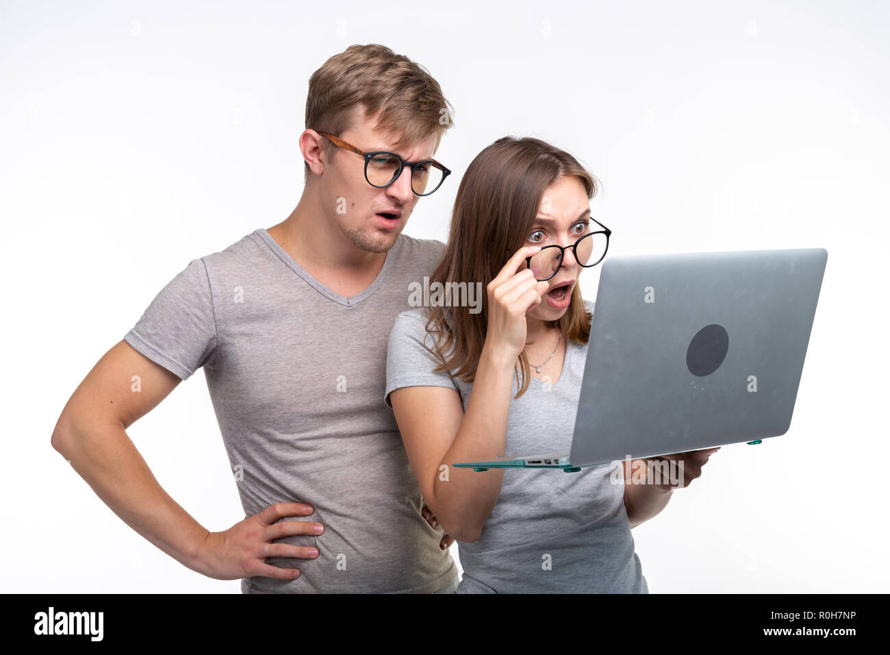 Nerds, study, people concept - a couple of students look at the netbook ...
