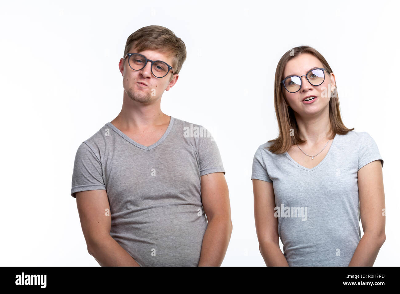 Education, people concept - a couple of young people in glasses look ...