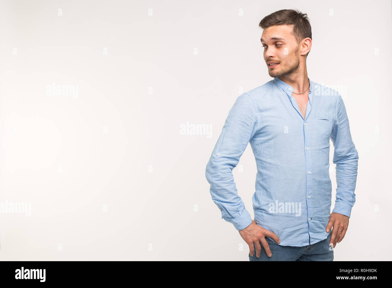 Handsome man standing and watching on empty place over the white ...