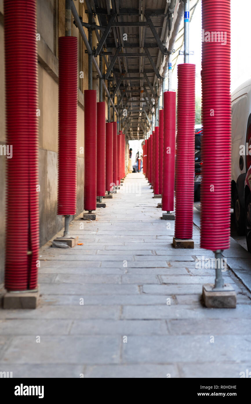 Row of red padded pillars under a scaffolding Stock Photo - Alamy