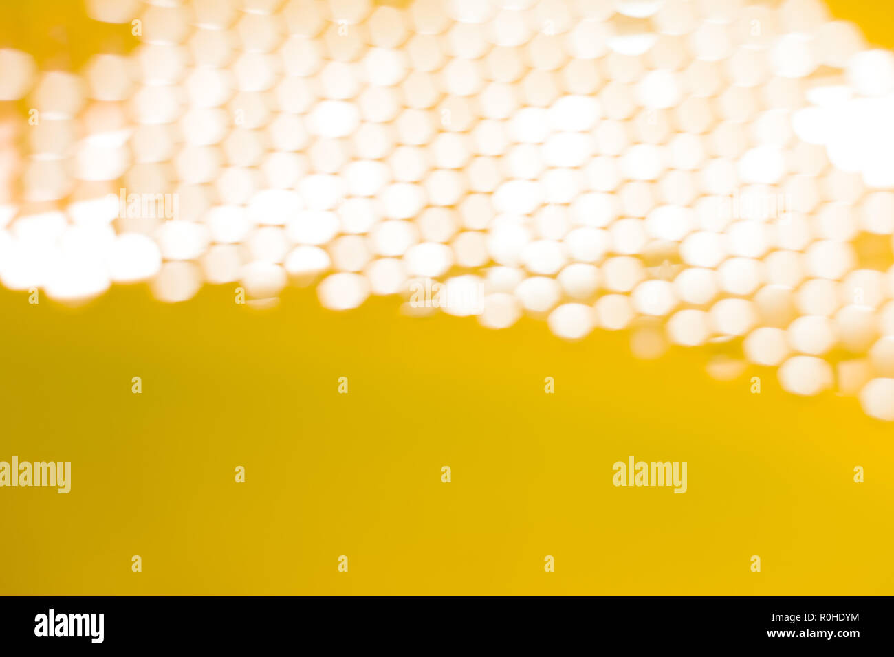 The light passes through the mesh structure, forming blurred hexagonal ...