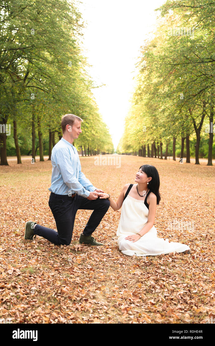 Man kneeling in front of his girlfriend and making marriage proposal in ...