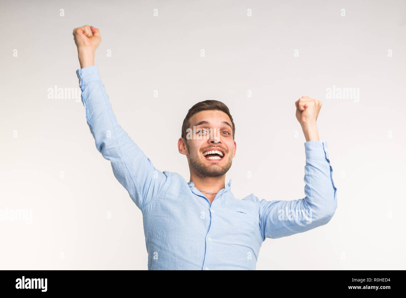 Victory and power concept - Handsome man raising one hand above his ...