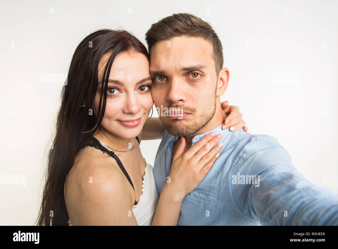 Young attractive funny couple taking selfie together on white ...