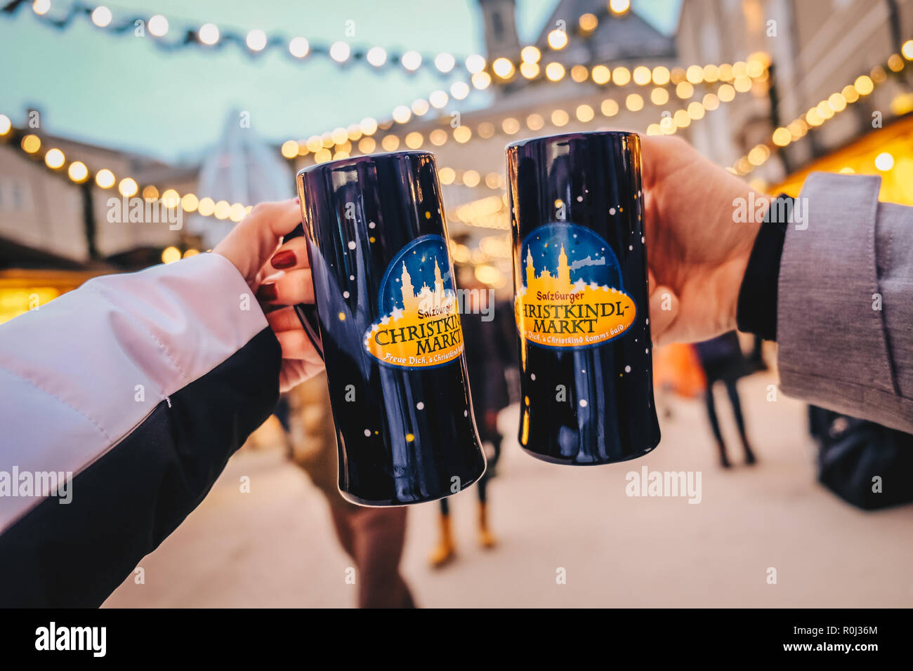 Tourists holding Salzbur Christmas Market mulled wine punch mugs with ...
