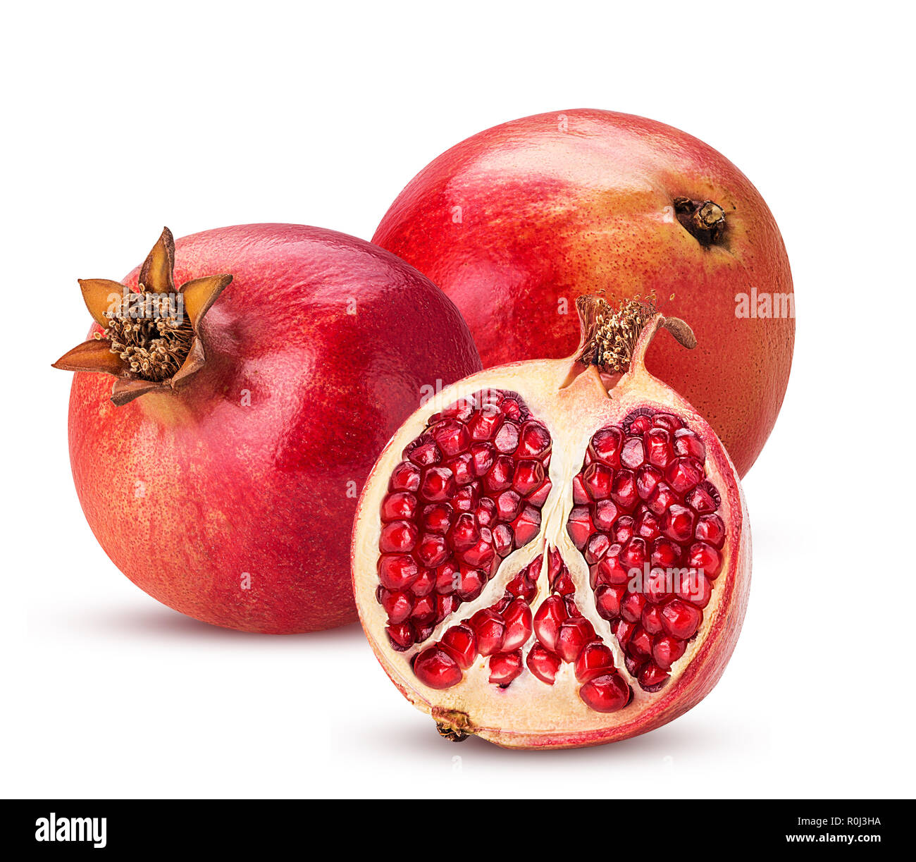 Two pomegranate and one cut in half isolated on white background ...