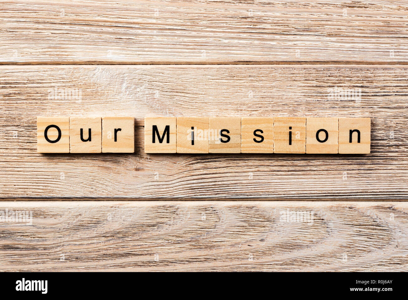 our mission on word written on wood block. our mission text on table ...
