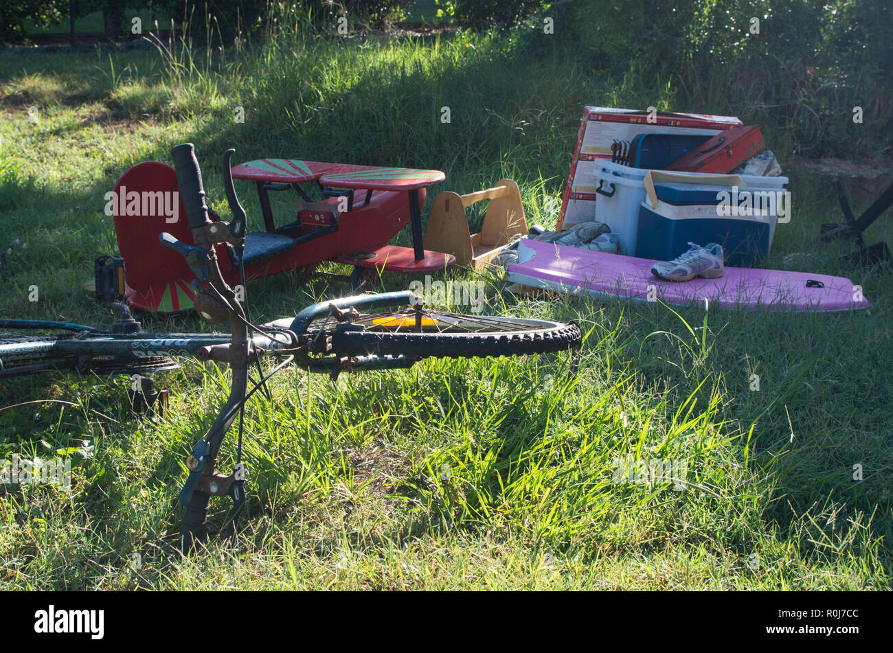Discarded household items thrown in a messy pile in a yard Stock Photo ...