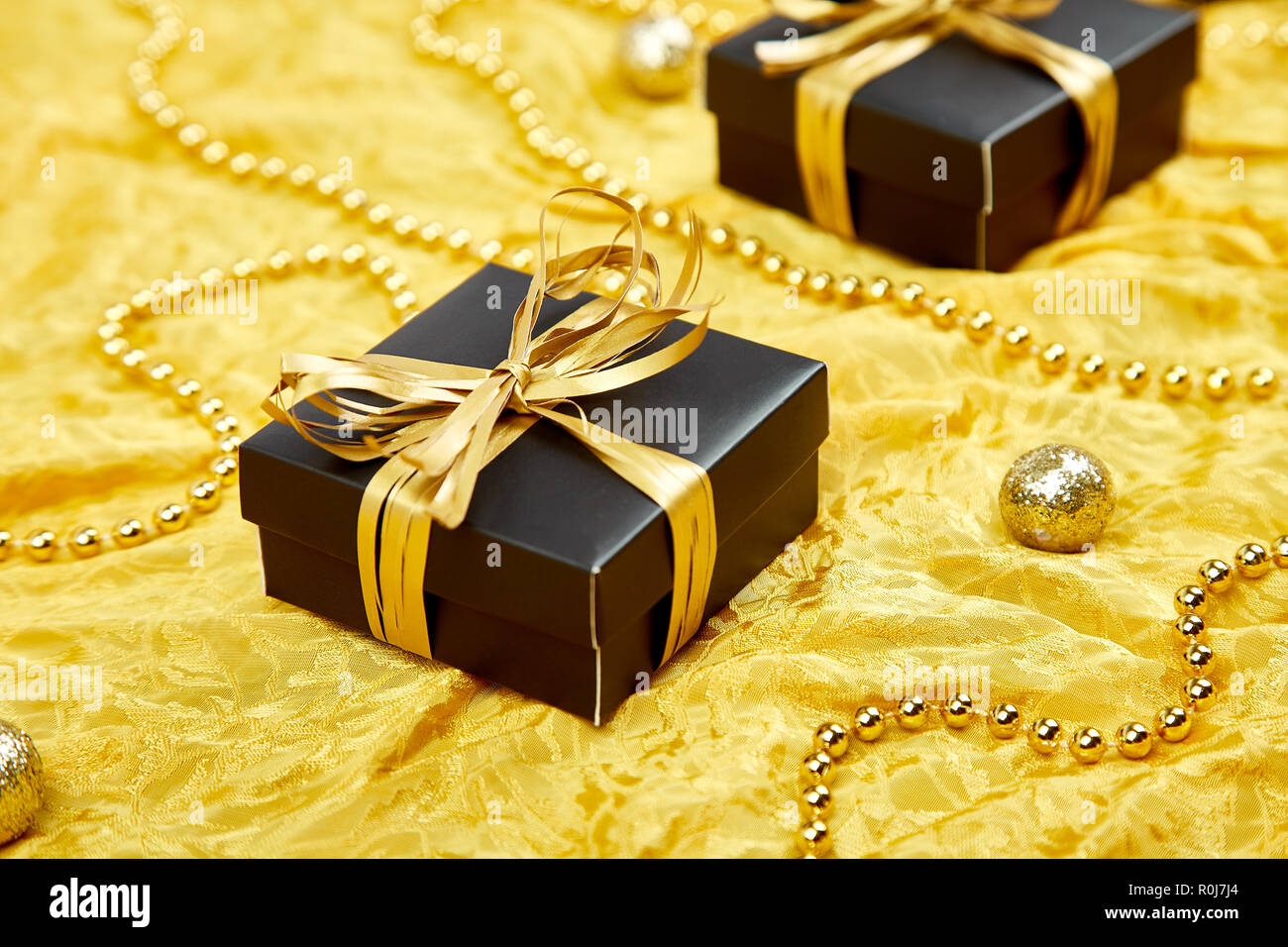 Luxury black gift boxes with gold ribbon on shine gold background ...