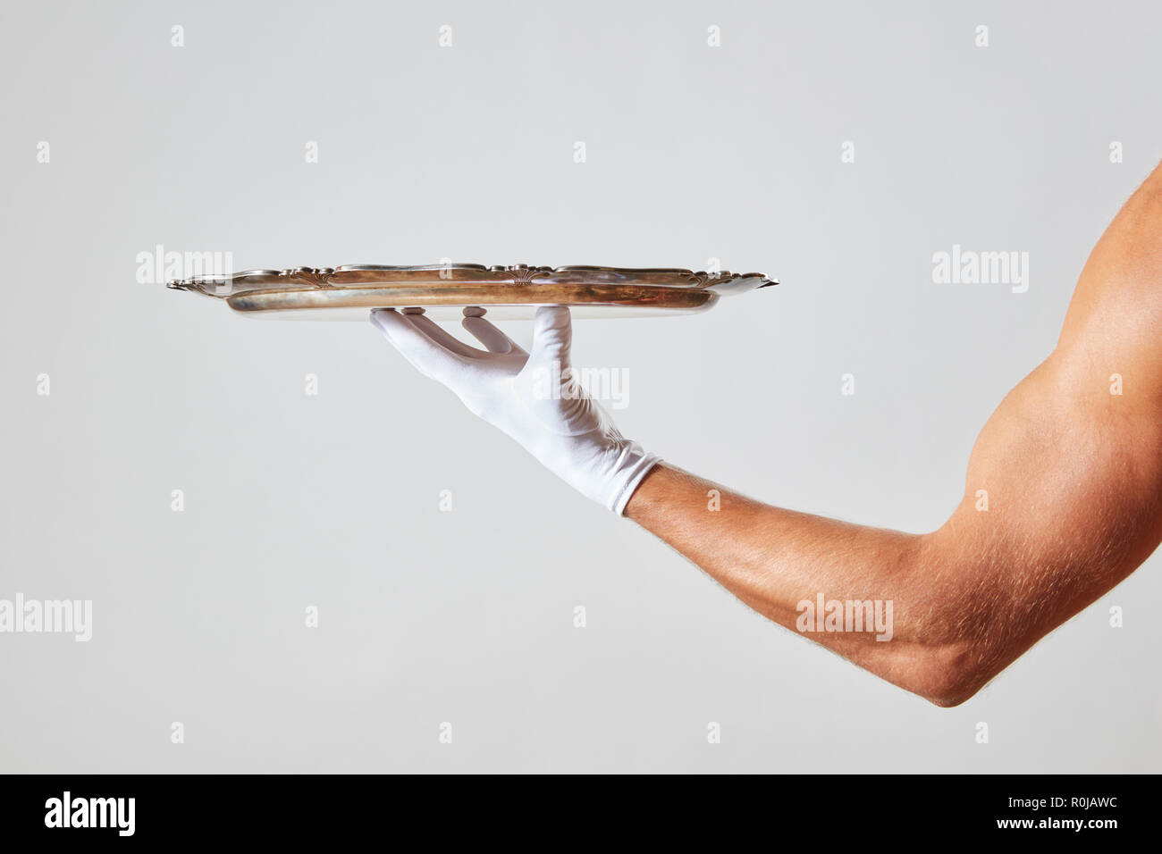 Waiter with muscular hand in a white glove holding a metal empty tray ...