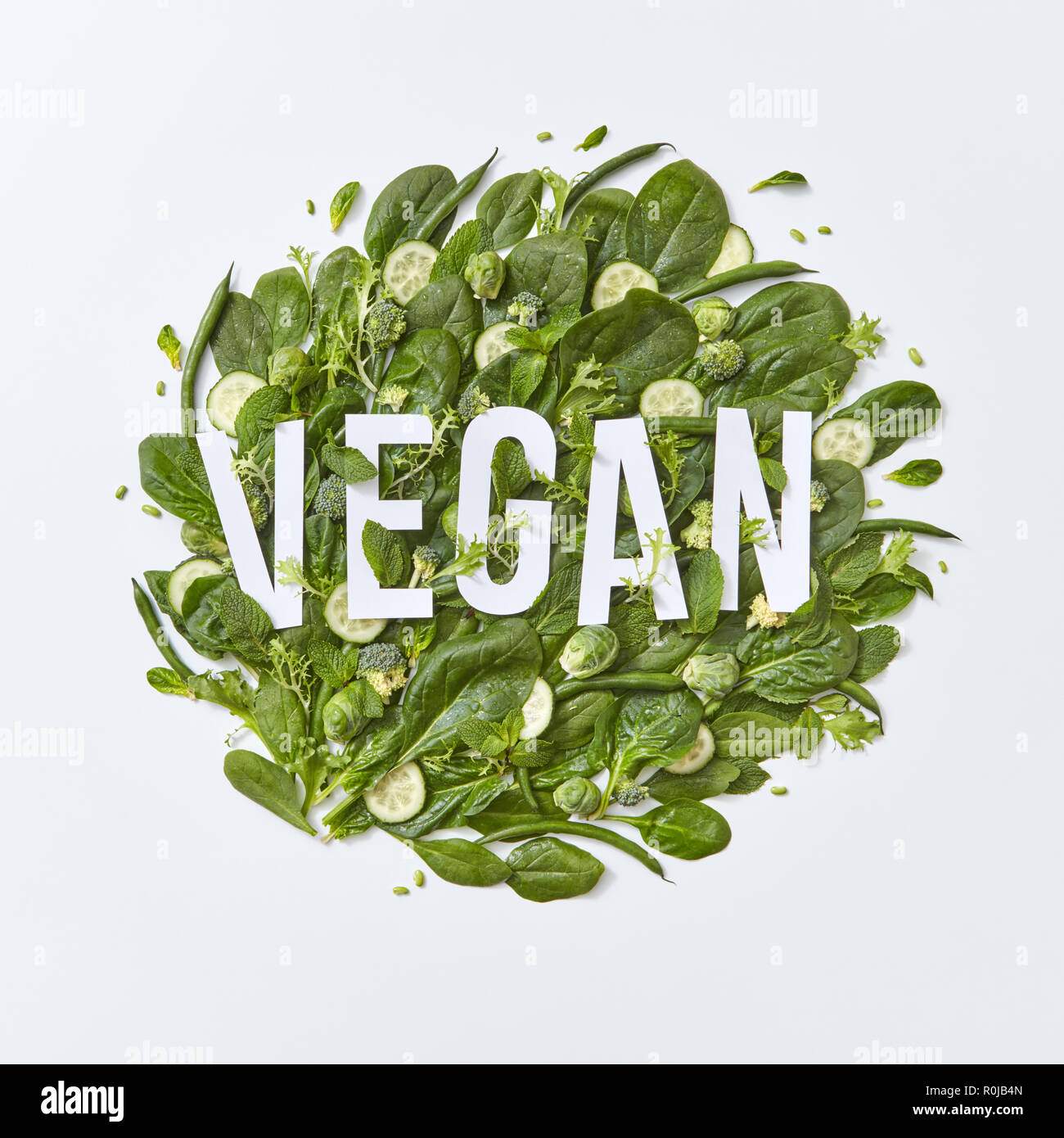 Round composition of different green vegetables with vegan paper ...