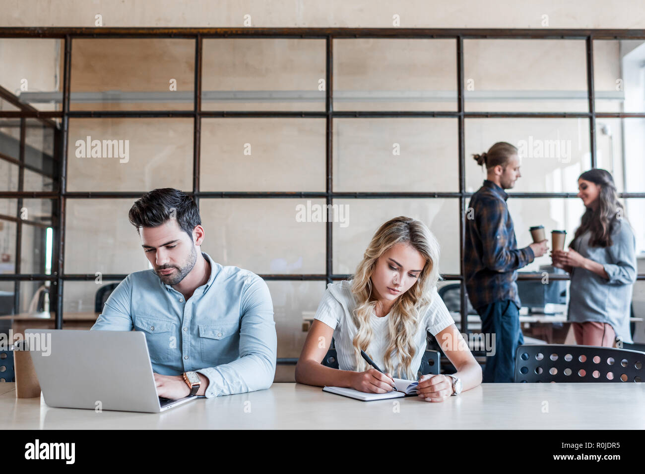 young business people working at workplace while colleagues drinking ...