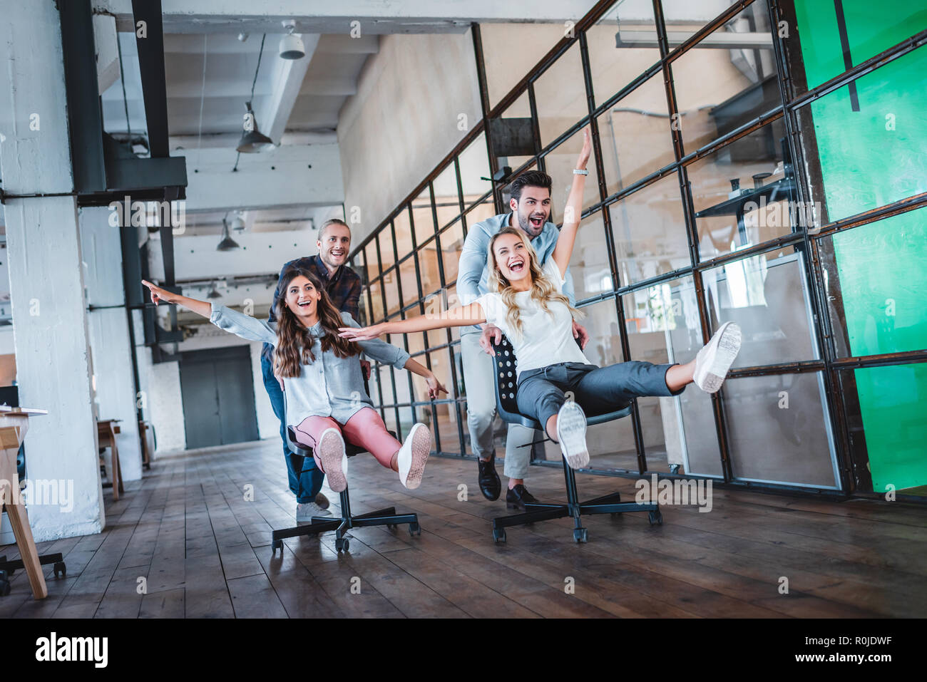 cheerful young colleagues having fun together at workspace Stock Photo ...