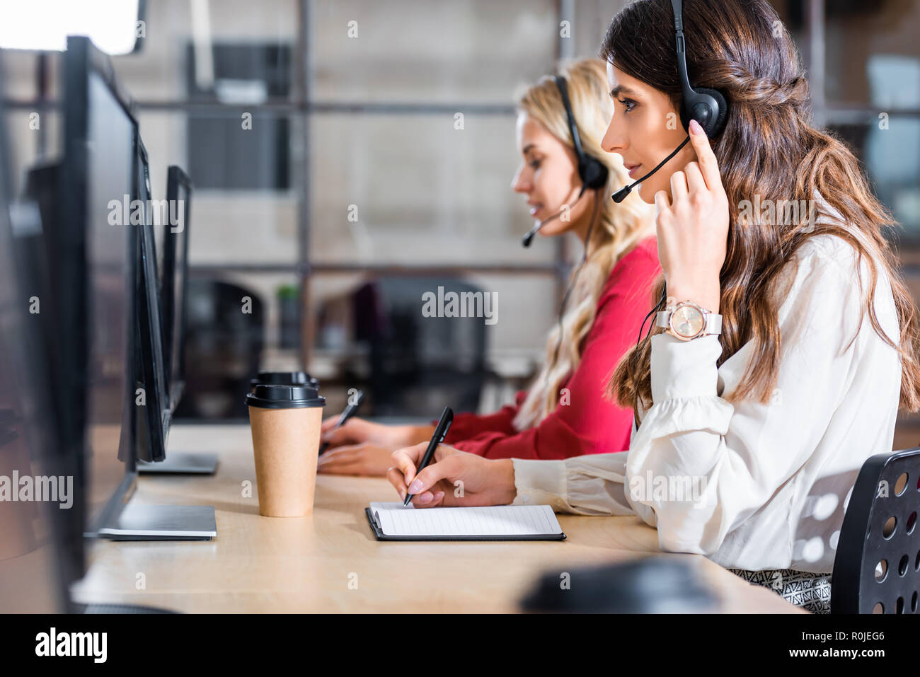 side view of female call center operators working at workplace in ...