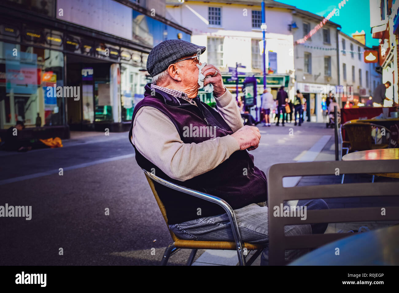 Man passing the time of day away in a market town in South Wales UK ...