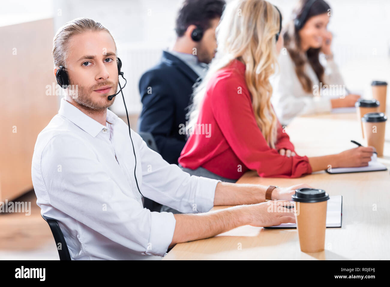 selective focus of call center operators working at workplace with ...