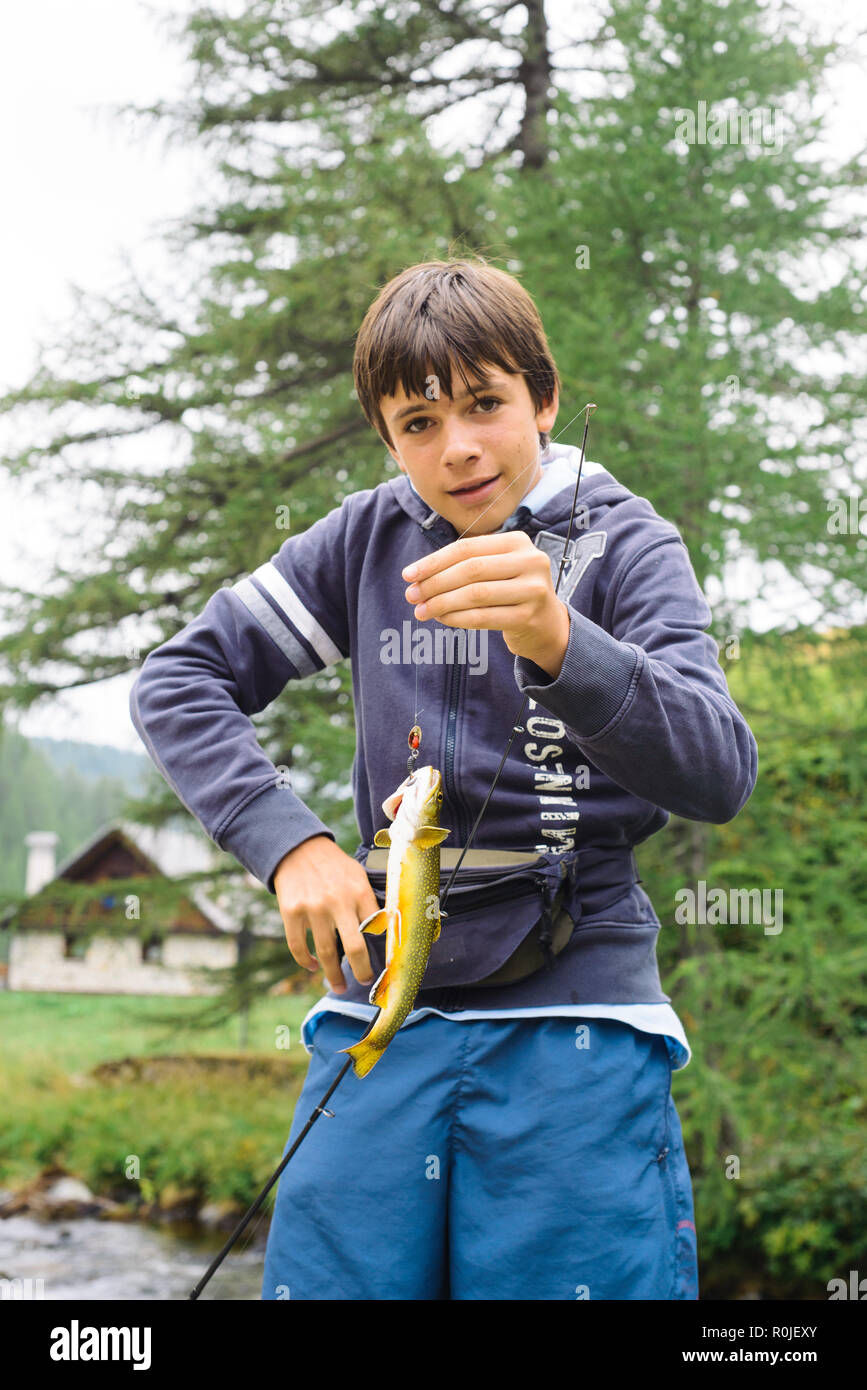 little boy with trout caught in mountain river in the alps Stock Photo ...